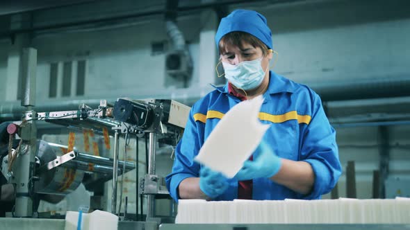 Female Person Separating Paper Tissues and Placing Them Onto a Conveyor ...