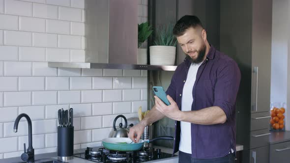 Man Cooking and using a Smartphone for Video call, Smiling and Talking ...