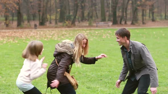 Dad trying to catch daughter while she's hiding behind mom, Stock Footage