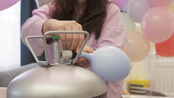Woman Using Helium Tank Blowing Up Balloons to Decorate Home for Party ...