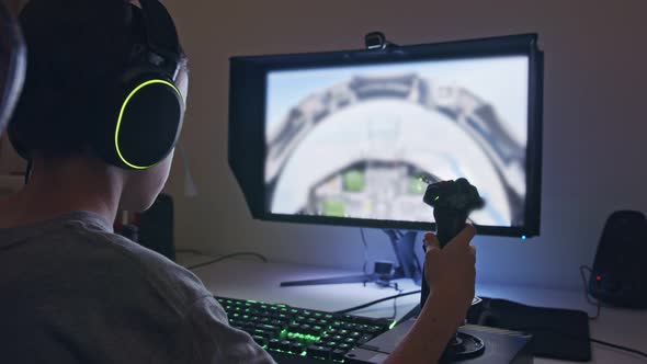 Young boy playing a flight simulator wearing a headset, Stock Footage
