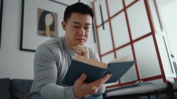 Positive Asian man reading book, Stock Footage | VideoHive