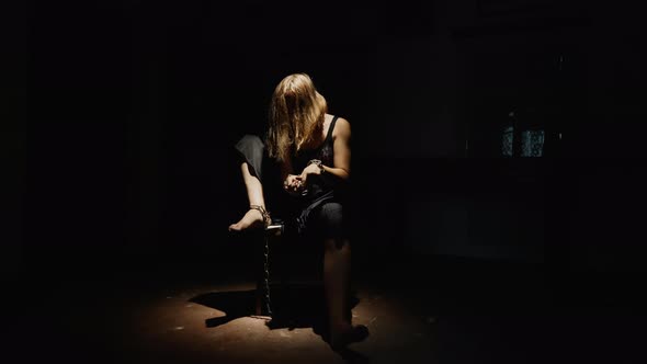 Woman Chained Sitting on a Chair in a Dark Creepy Room, Stock Footage