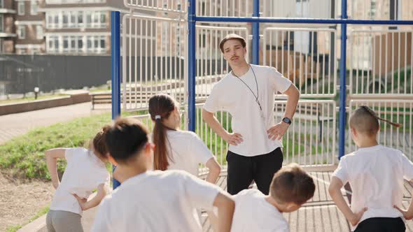 School Kids Do Exercise on Sport Class with Their Teacher Outdoor ...