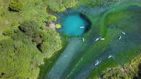 Serene landscape of a gleaming river surface. Paddlers glide slowly ...