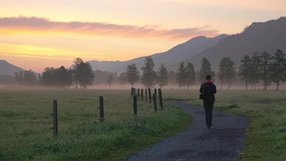 Man Walking Along Path Towards Misty Landscape At Dawn, Stock Footage