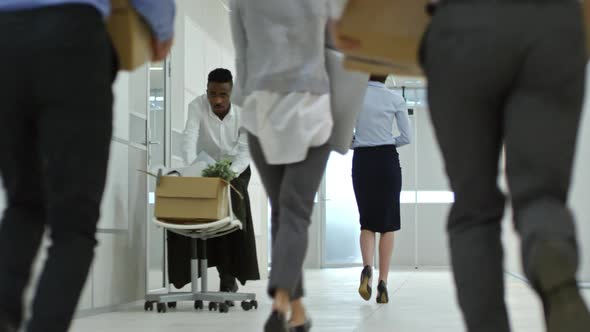 Office Workers Running through Hallway with Cardboard Boxes by Pressmaster