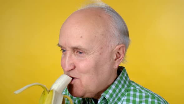 Portrait Of Cheerful Senior Man Eating Banana Stock Footage Videohive