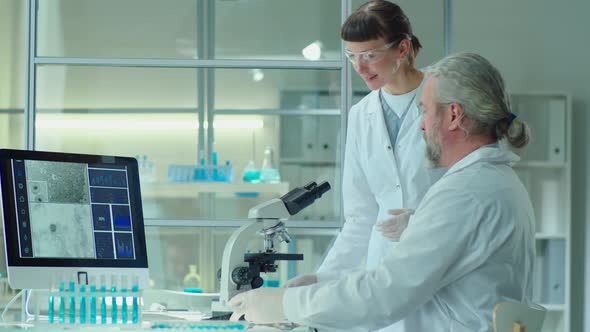 Senior Scientists Working with Young Female Colleague in Lab, Stock Footage
