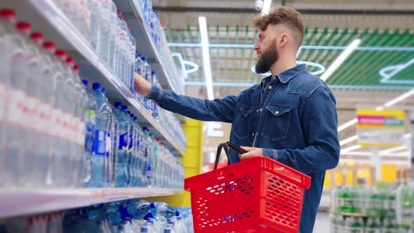 Male Shopper is Buying Bottled Water in Supermarket, Stock Footage