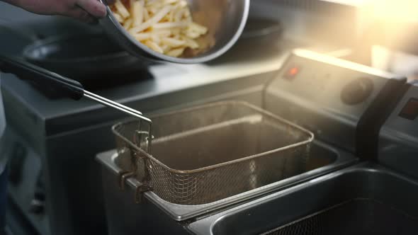 The Cook Fills the Fryer with Raw Potato for Making Fries in Slow ...