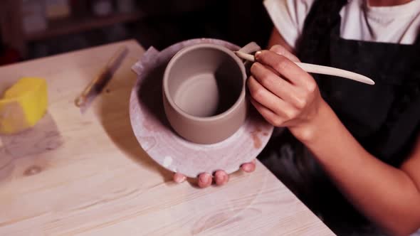 Pottery in the Studio Asian Woman Holding a Cup on the Plate and ...