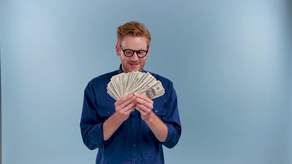 Funny Rich Man with a Fan of Dollars Sniffing Money Isolated on a Blue ...